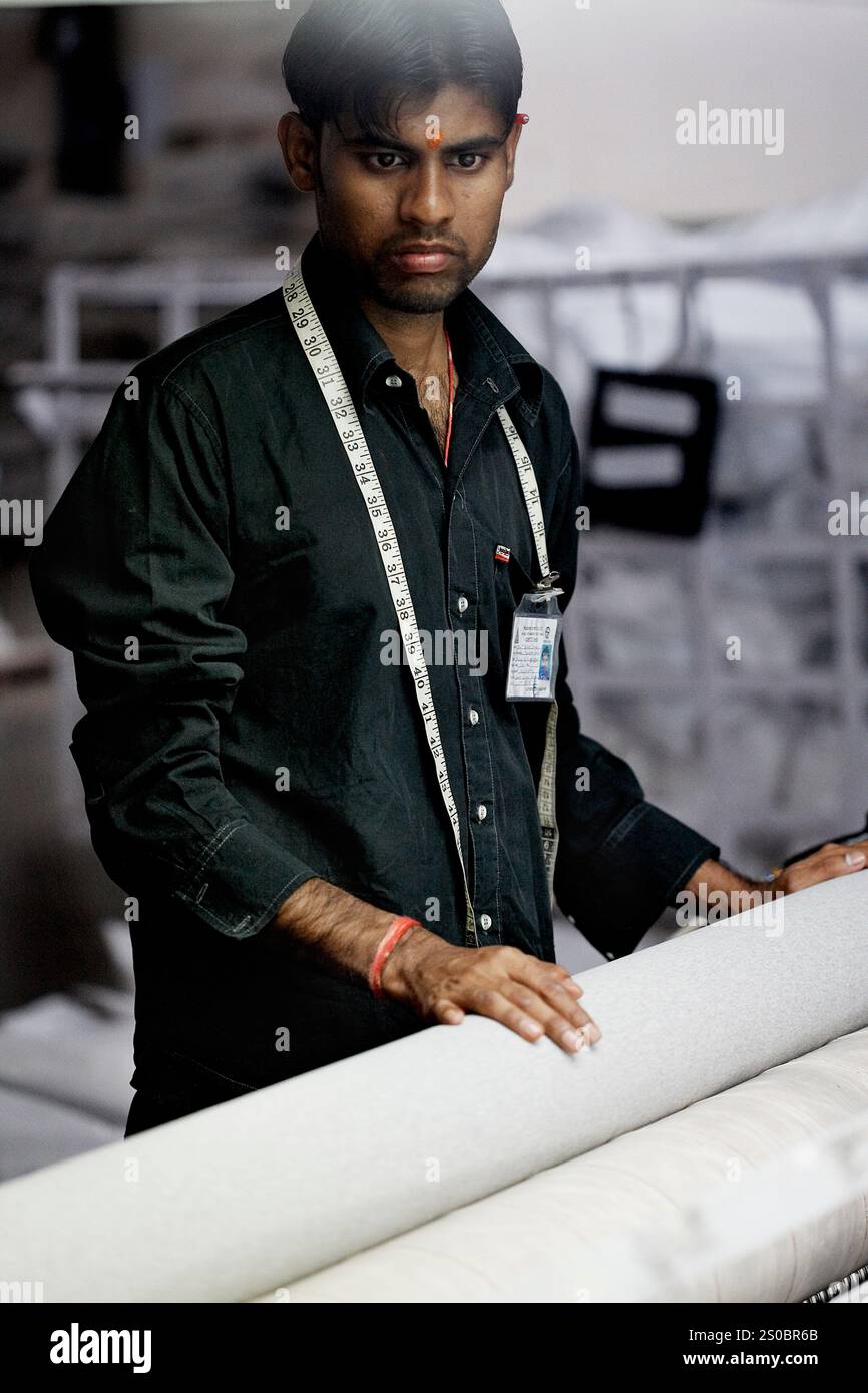 An Indian factory worker standing at a roll of cotton fabric Stock ...