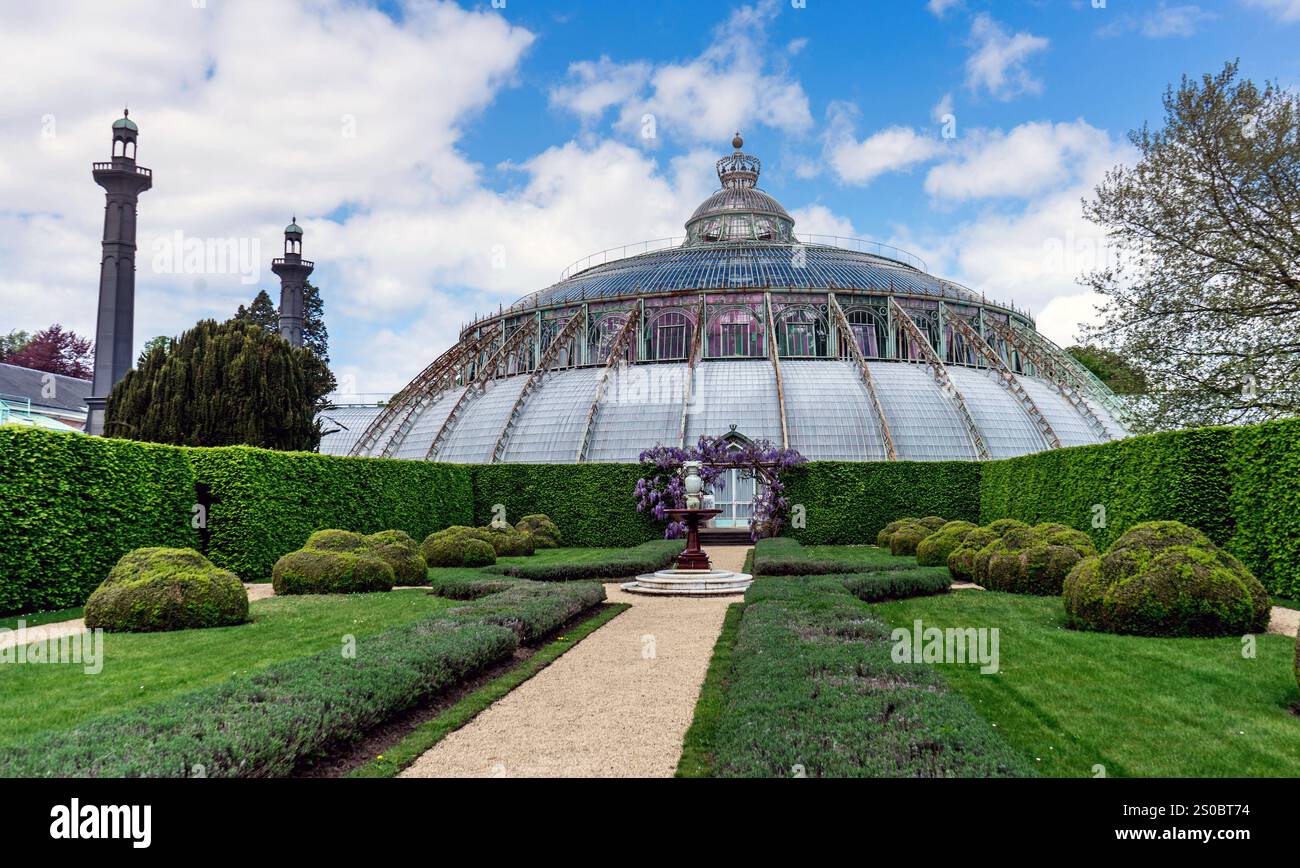 A beautiful glass conservatory surrounded by manicured hedges and lush ...