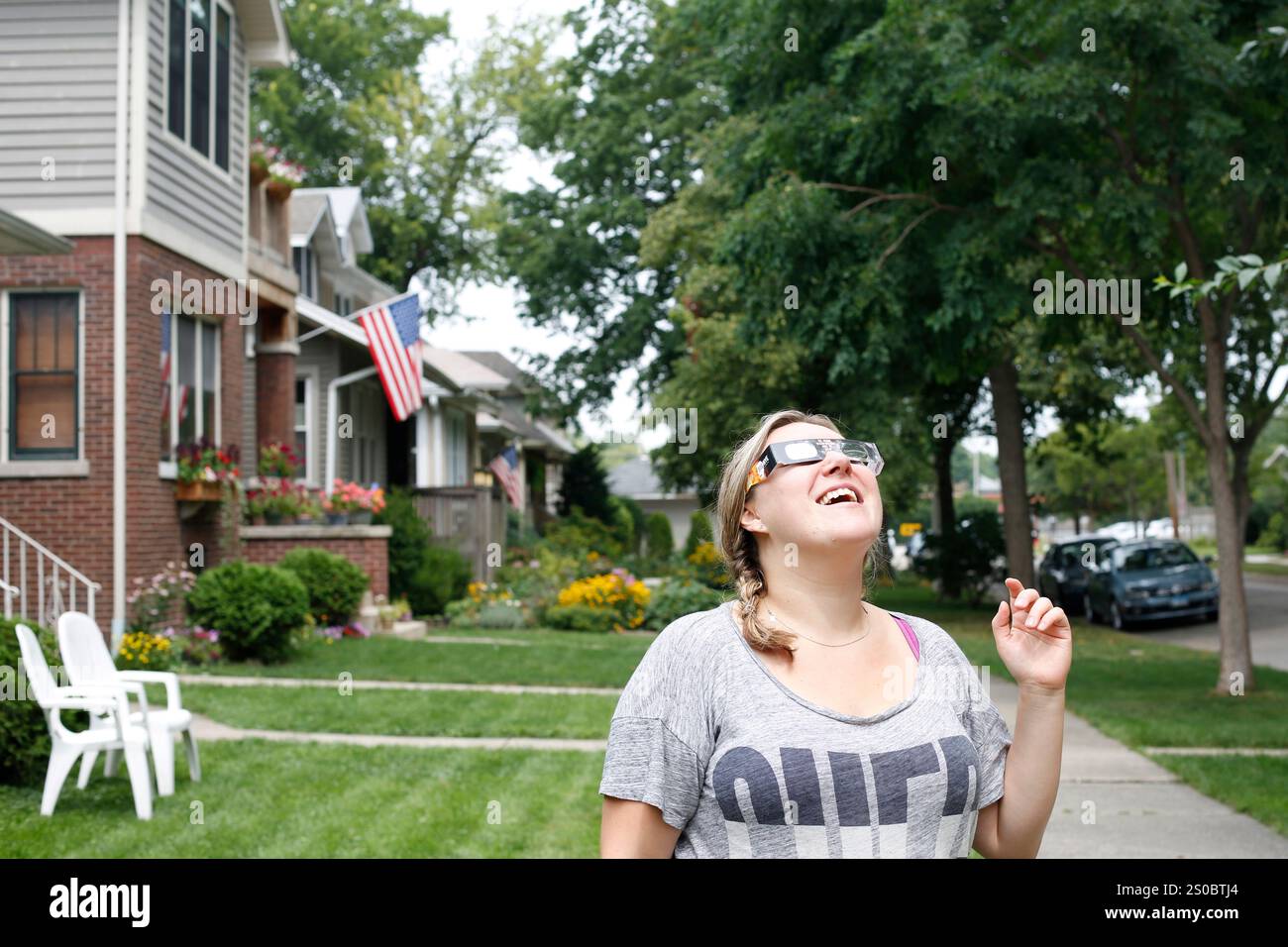 Woman watching solar eclipse in suburb Stock Photo - Alamy