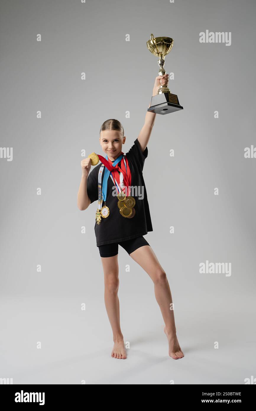 Girl proudly displays her dance trophies and medals for achievements in ...