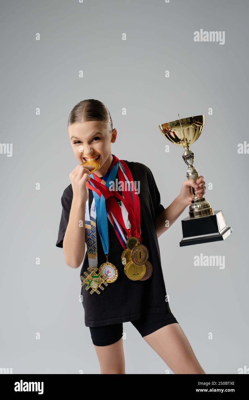Girl celebrates dance win with a trophy and several medals Stock Photo ...