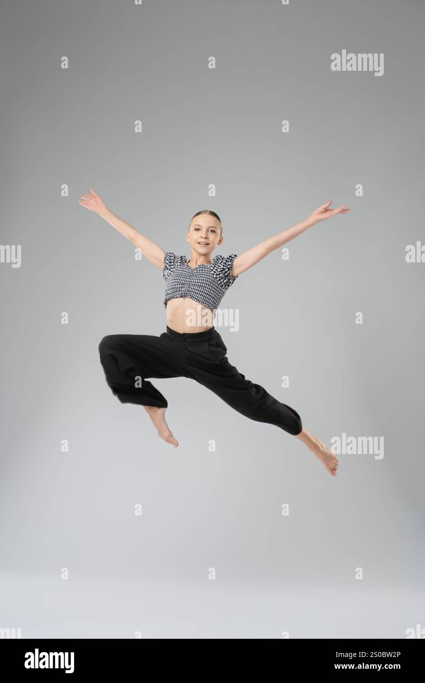 Dynamic girl performing an impressive dance leap in an artistic studio ...