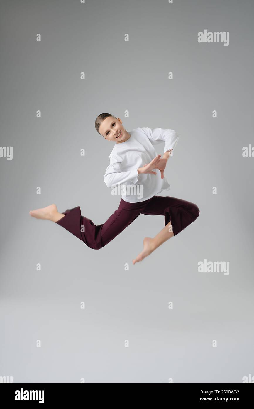 Girl performing an artistic dance leap in a studio setting Stock Photo ...