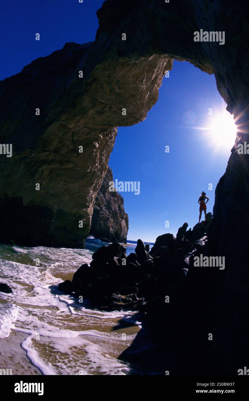 A woman looks under a Sea Arch, Baja, Mexico Stock Photo - Alamy