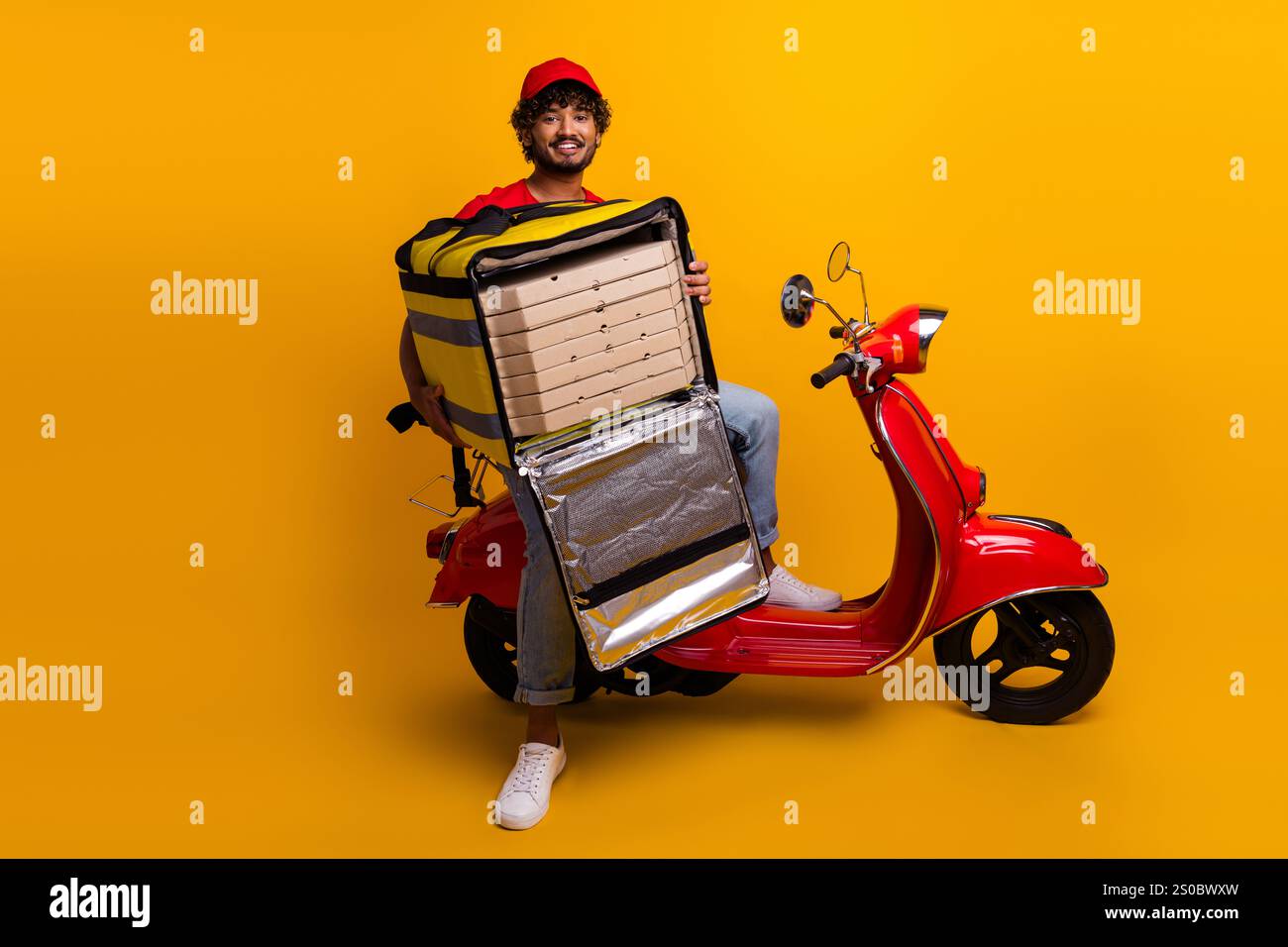 Smiling delivery man with yellow thermal bag and boxes on scooter ...