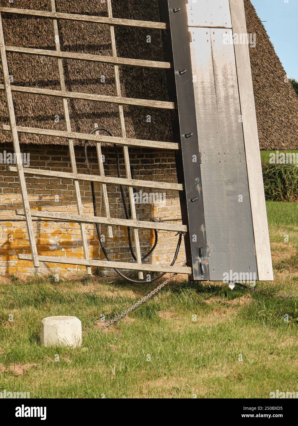 A serene view of the sailstock end of a traditional thatched windmill ...