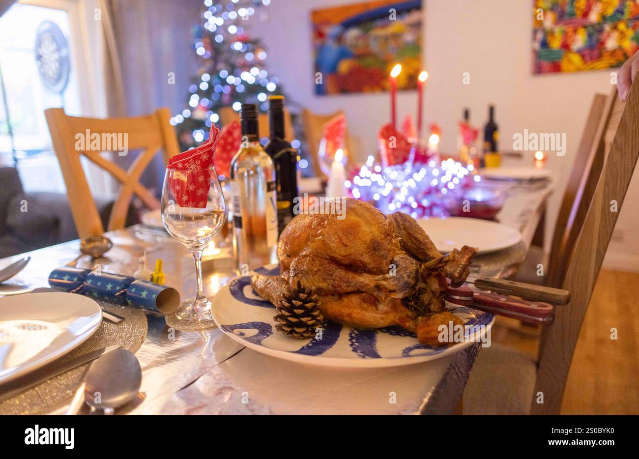 A table laid for Christmas lunch with crackers and a roast Turkey. A ...