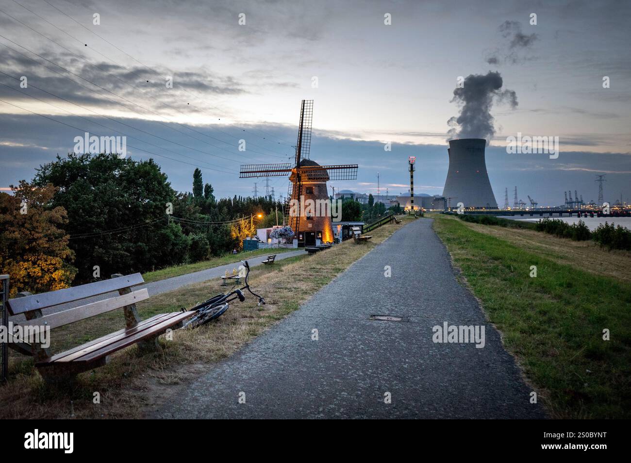 A scenic view featuring a traditional windmill beside a pathway, with a ...