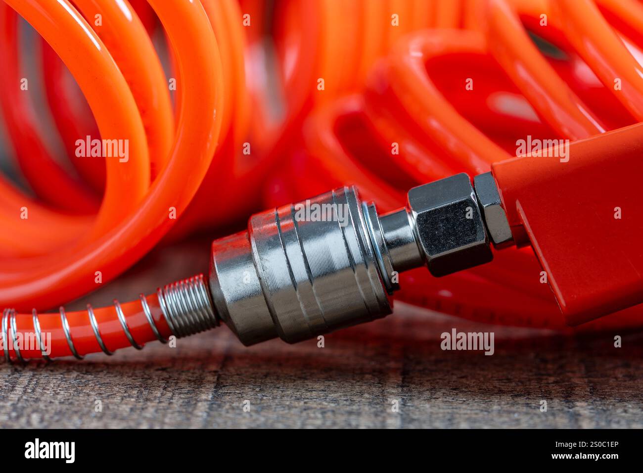 An orange air hose with an hose coupling , close up. Detail of air ...