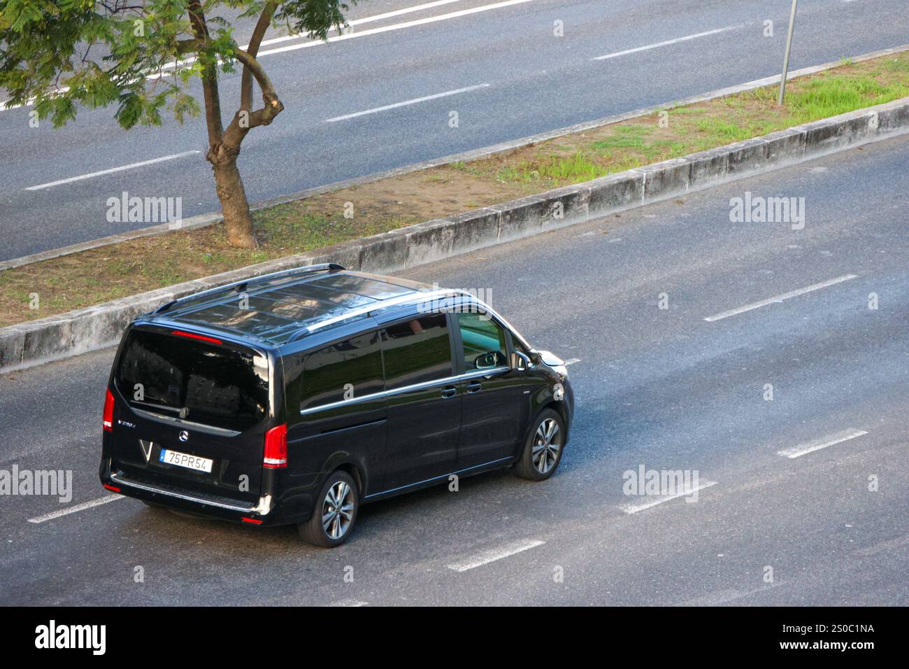 Black mercedes benz v class driving on the road near the sidewalk Stock ...