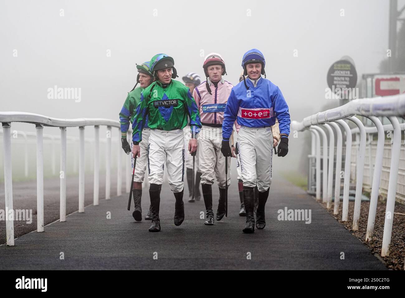 Jockeys head out for the first race in heavy fog during The Coral Welsh ...