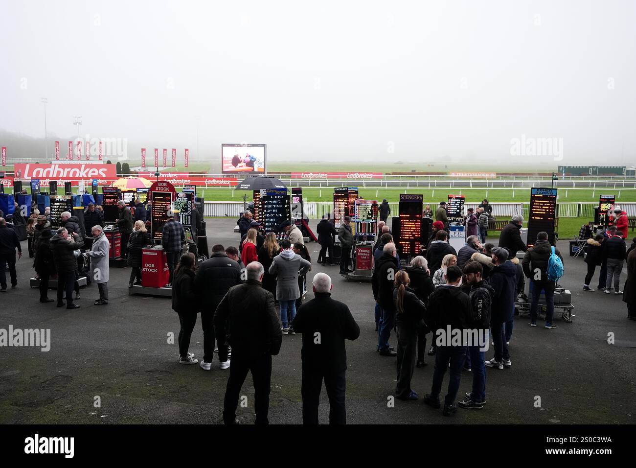 Racegoers browse bookmakers stalls ahead of Desert Orchid Chase Day at ...