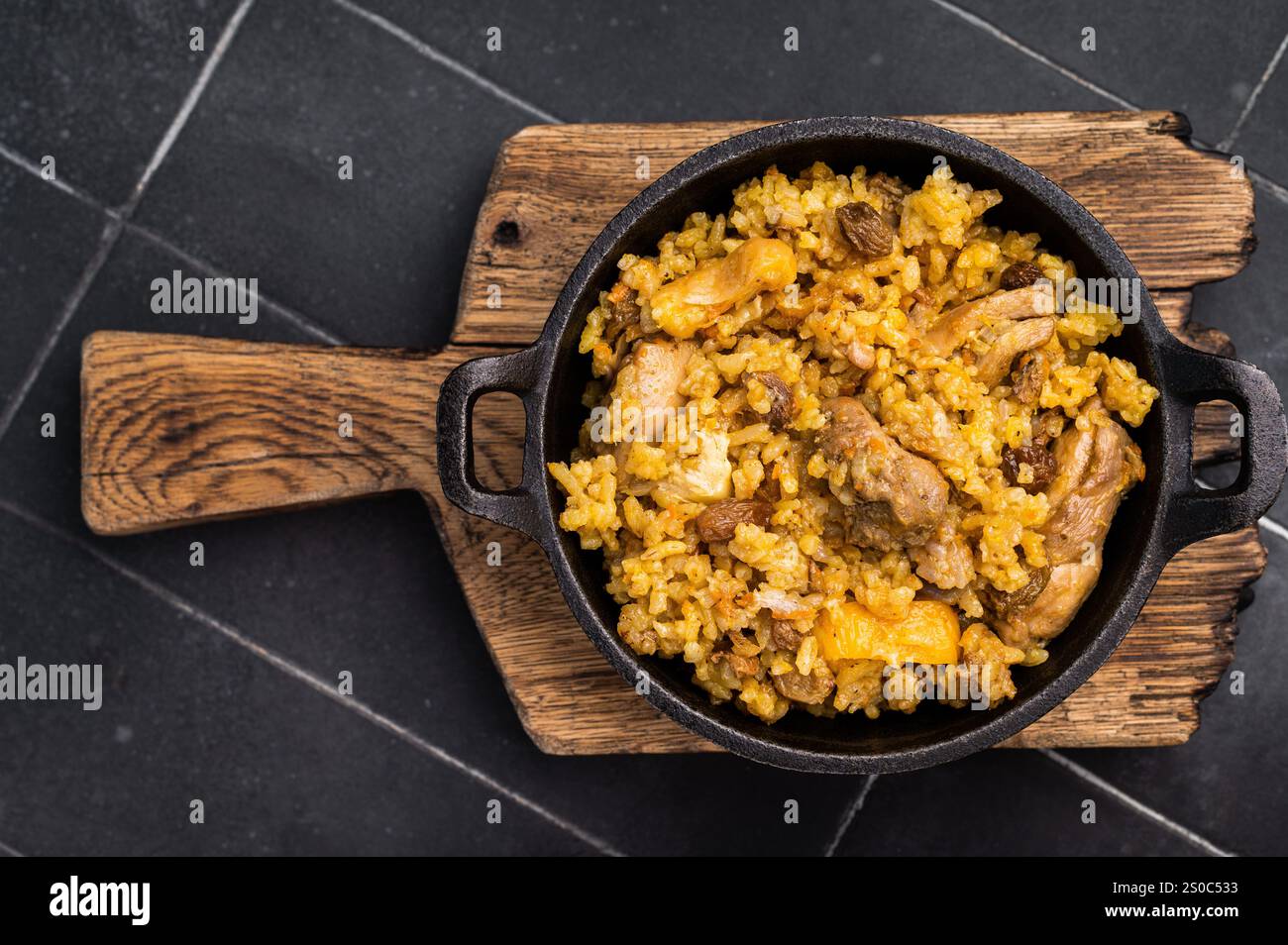 Pilaf with beef and lamb meat, vegetables in a skillet. black ...