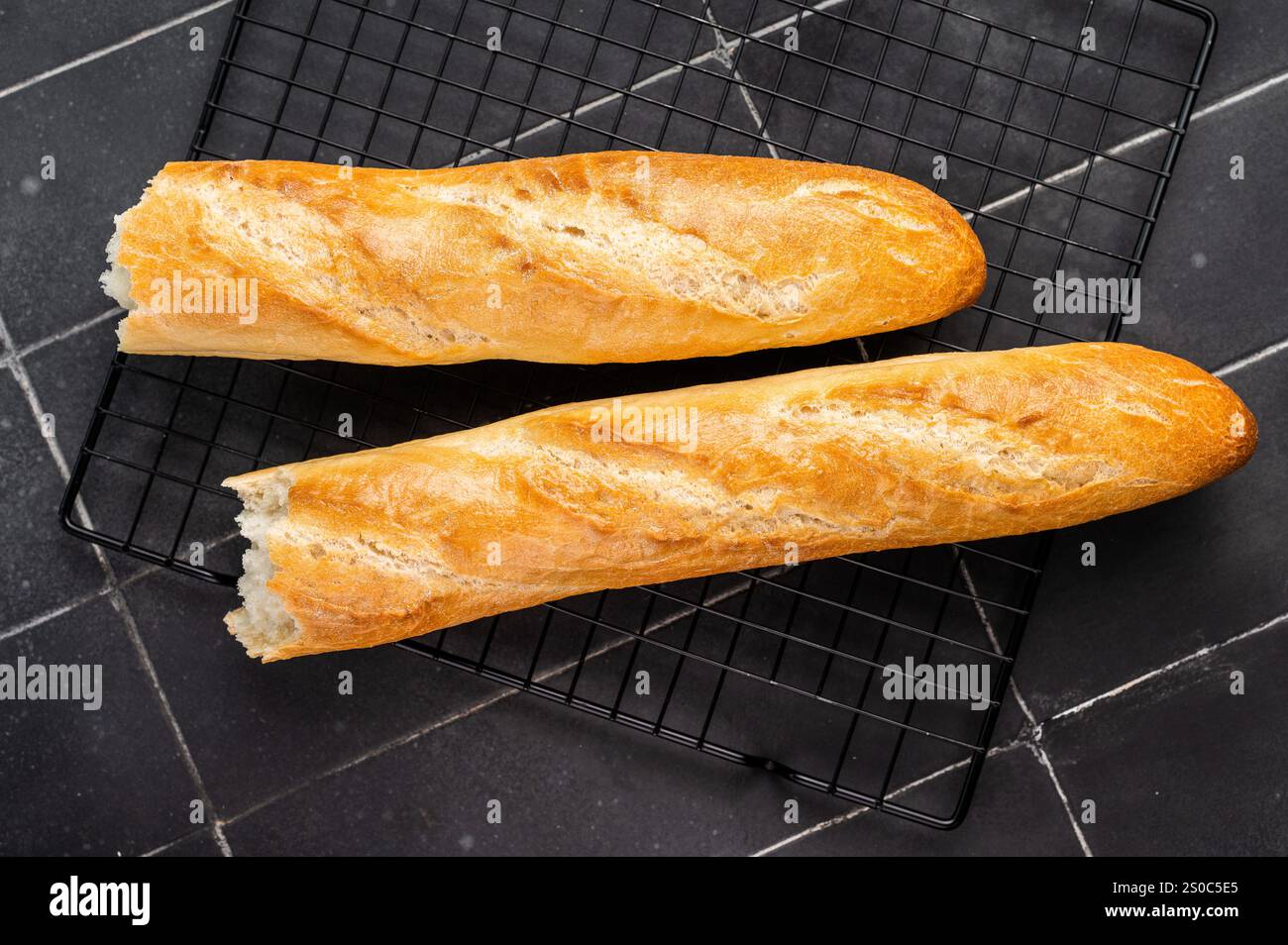 French bread baguette on a steel rack. black background. top view Stock ...