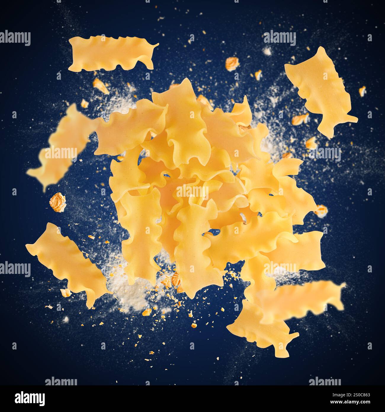Uncooked mafaldine pasta exploding on a blue background, creating a ...