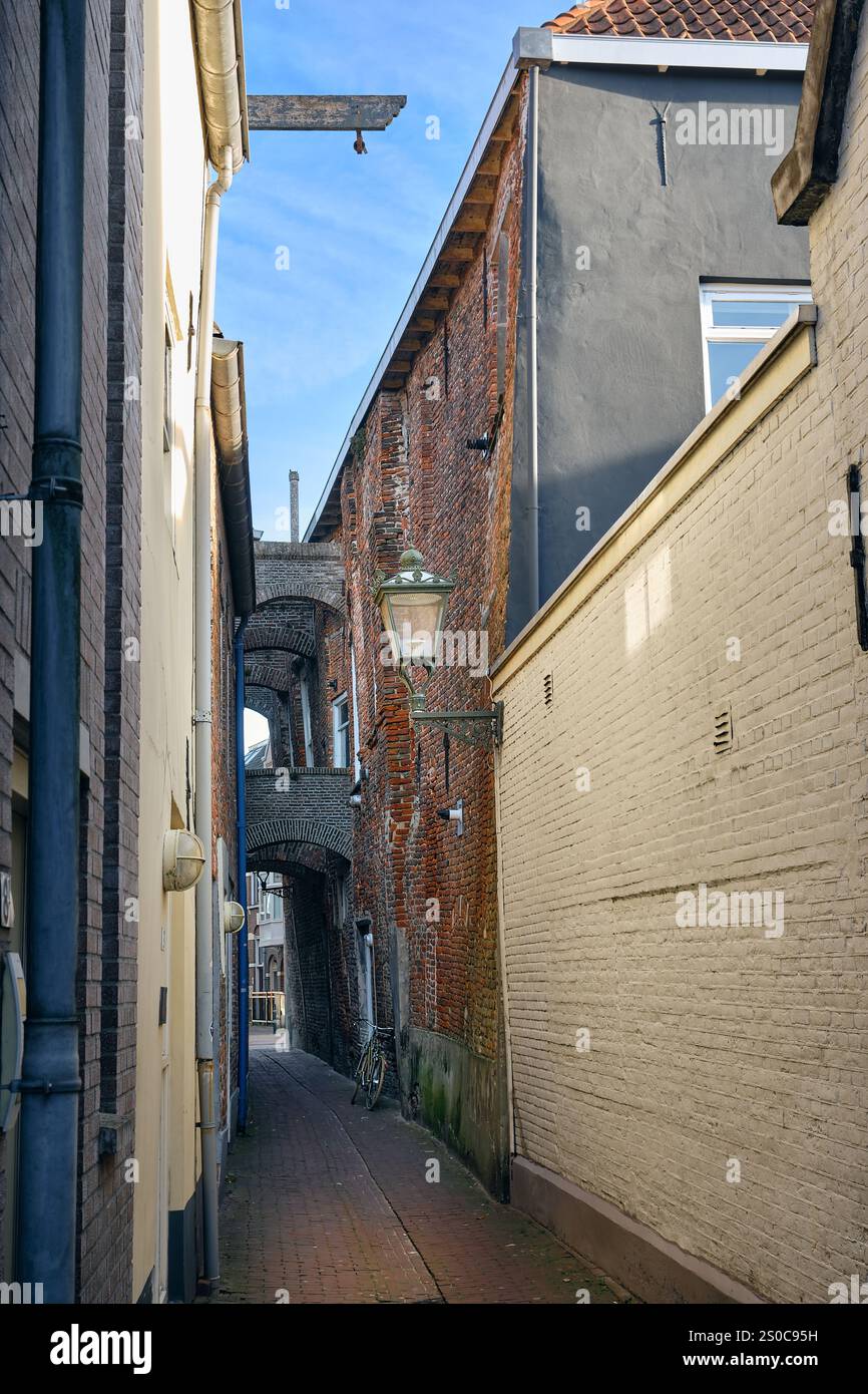 Historic narrow alley with red brick walls, arched structure, and ...