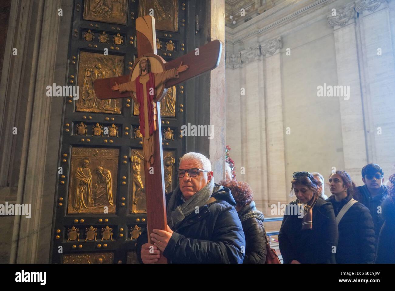 Vatican, Rome, Italy. 27 December 2024 Pilgrims carry the cross as they ...