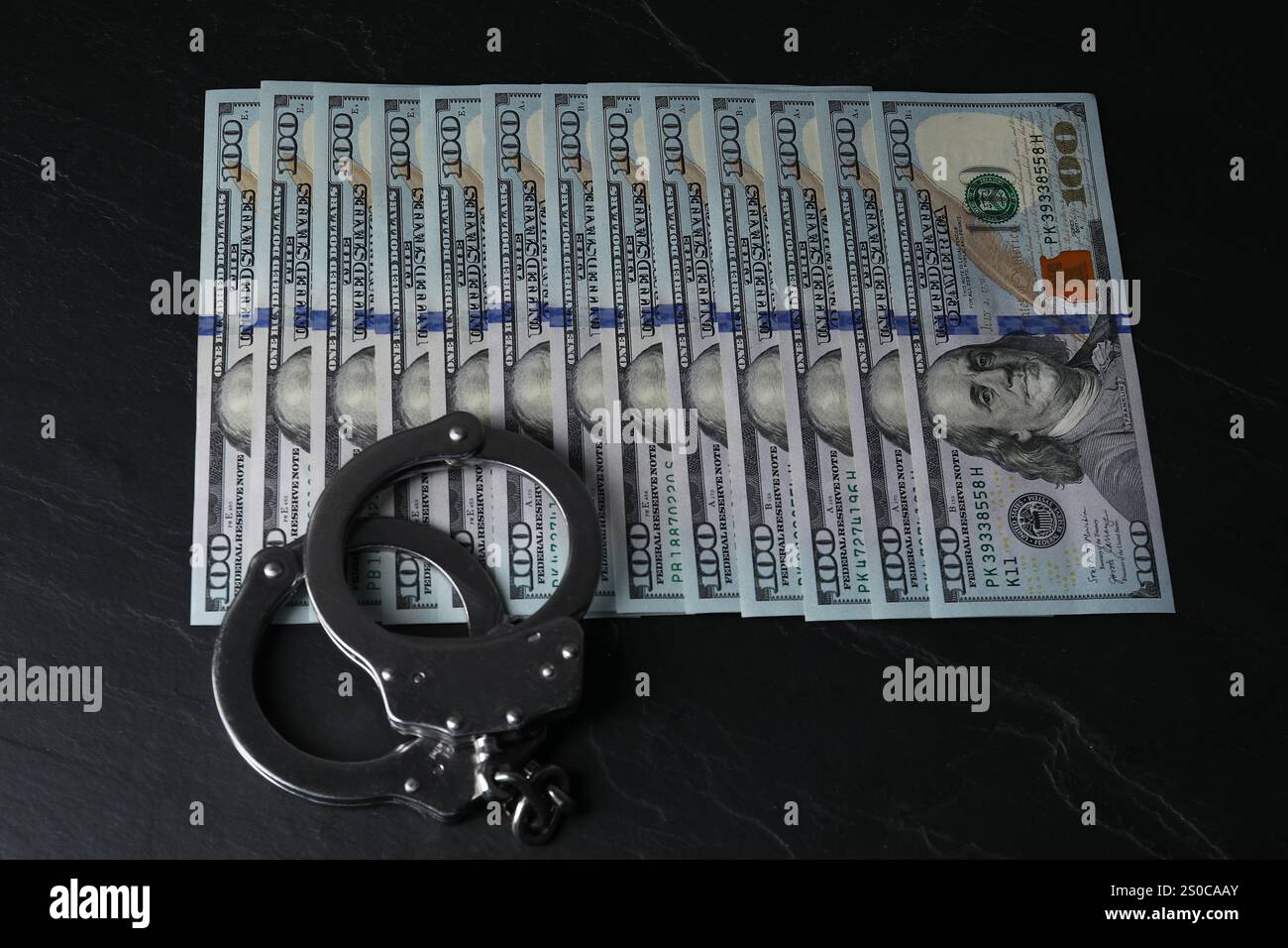 Corruption. Handcuffs and dollar banknotes on black table, above view ...