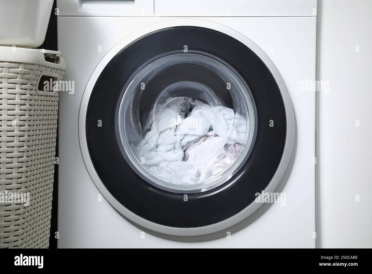 Washing machine with clothes as background, closeup Stock Photo - Alamy