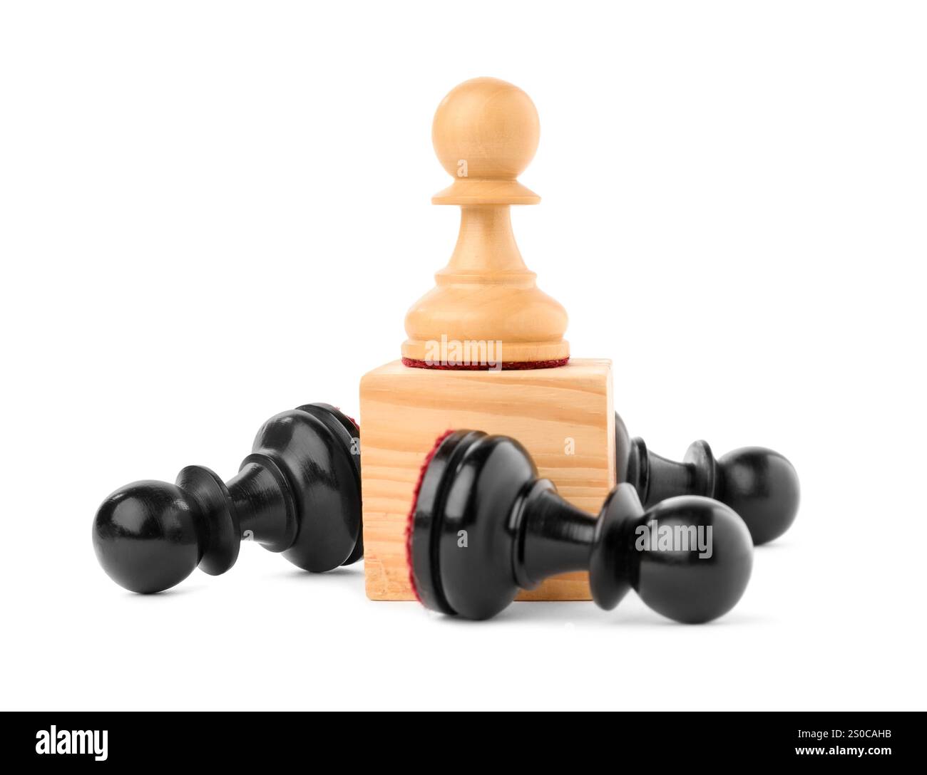 White pawn on wooden block among fallen black ones against white ...