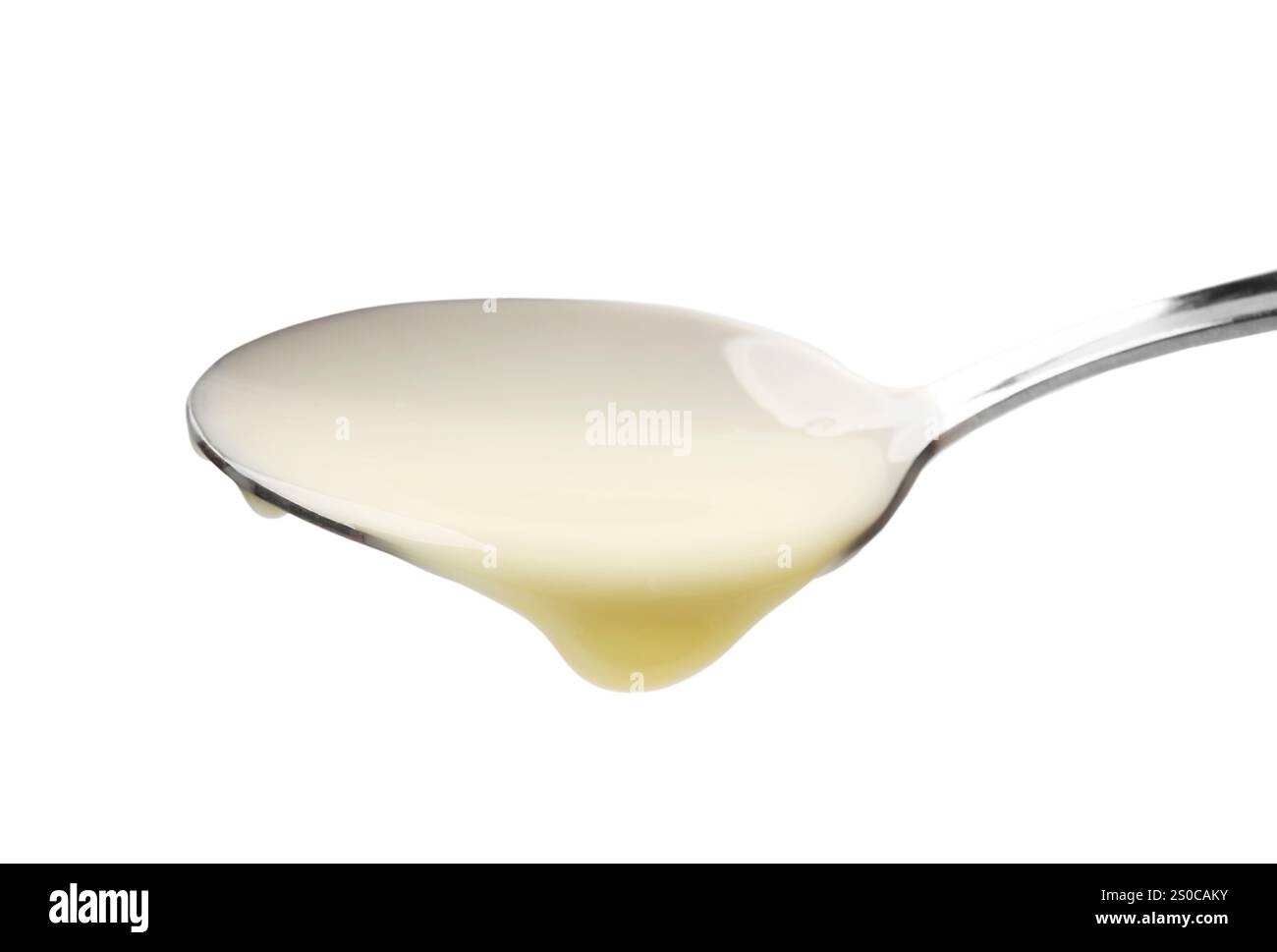 Delicious condensed milk pouring from spoon isolated on white Stock ...