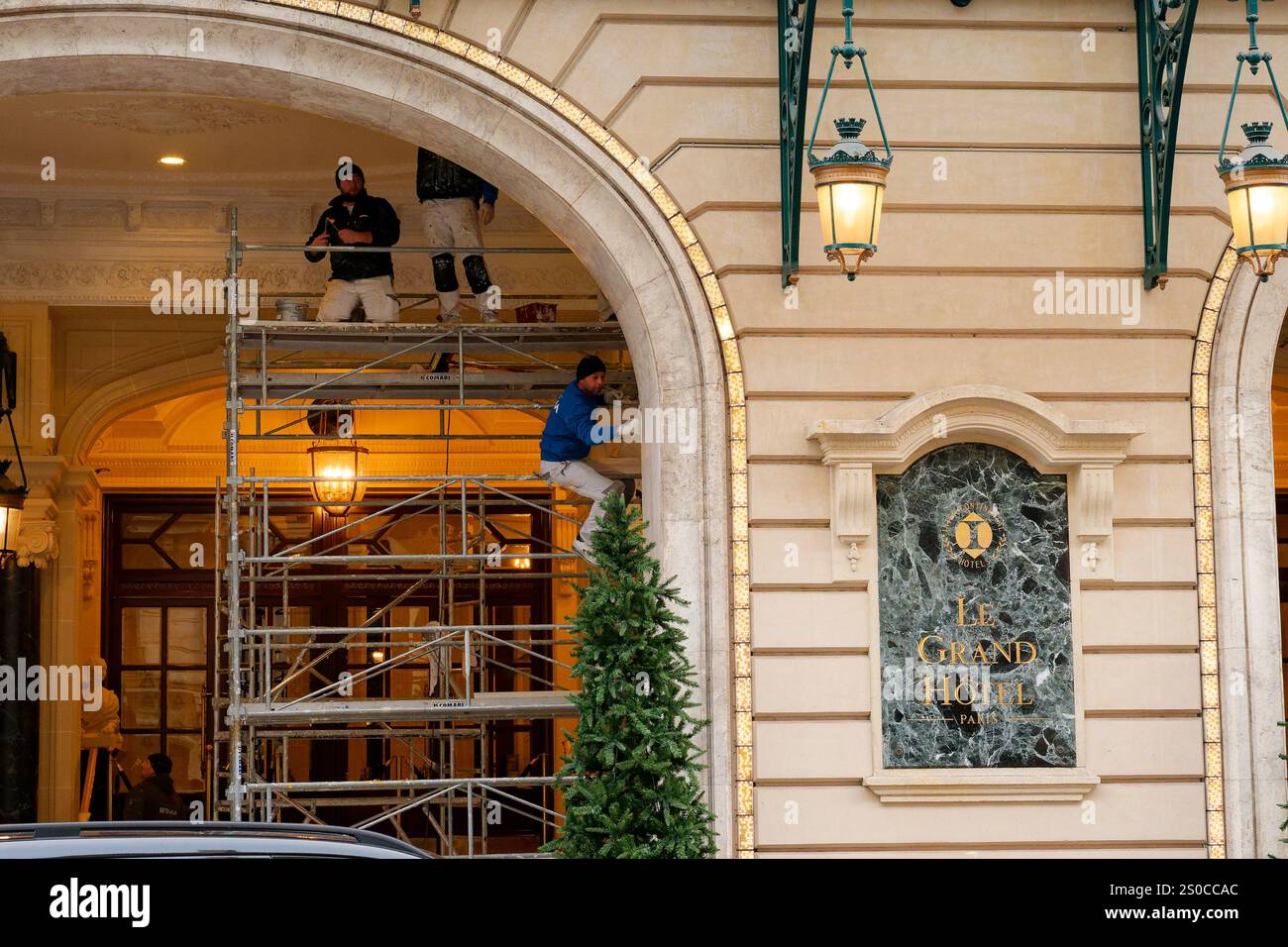Workers perform maintenance on the exterior arches of a historic ...