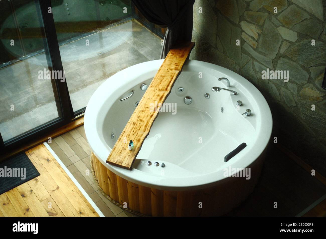 Top view of a modern round jacuzzi with natural light from a large ...