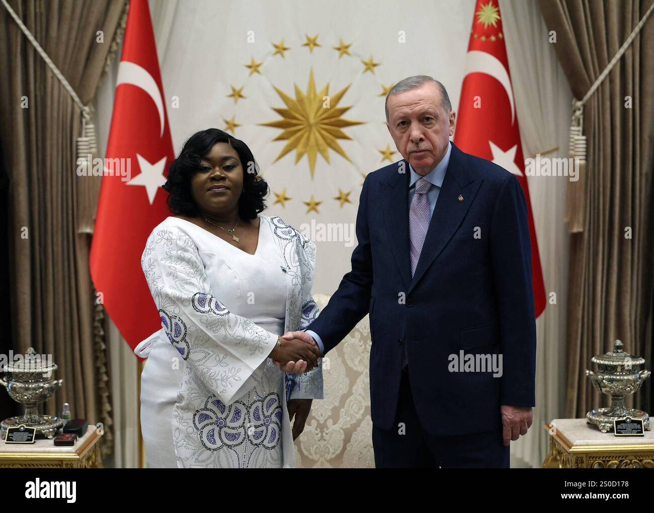 Turkish President Recep Tayyip Erdogan receives a copy of the ...
