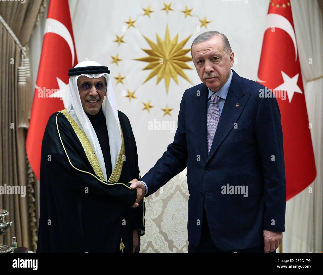 Turkish President Recep Tayyip Erdogan receives a copy of the ...