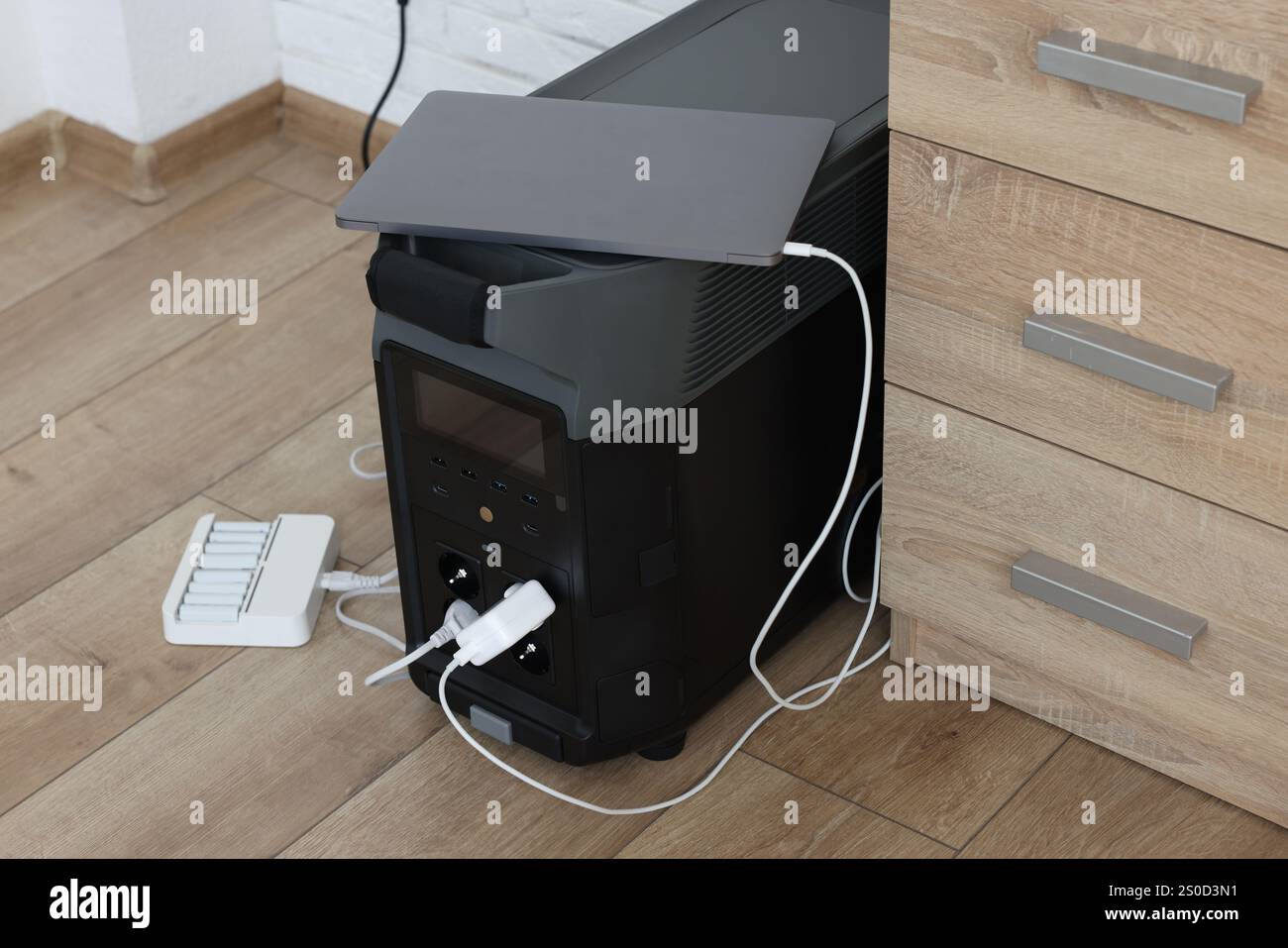 Modern portable power station, charging attached devices indoors Stock ...