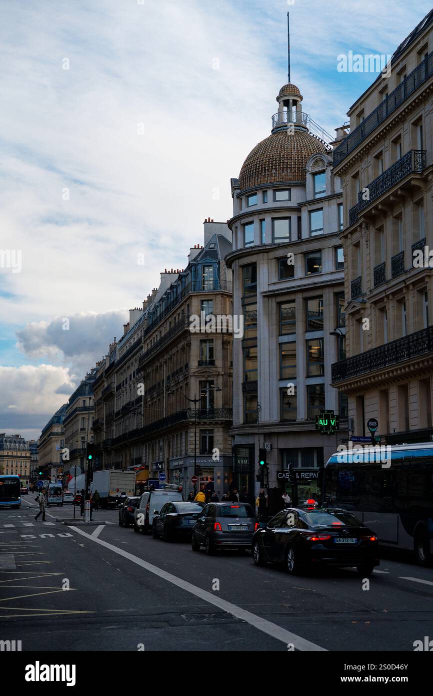 People move along a busy street in Paris with stylish architecture and ...