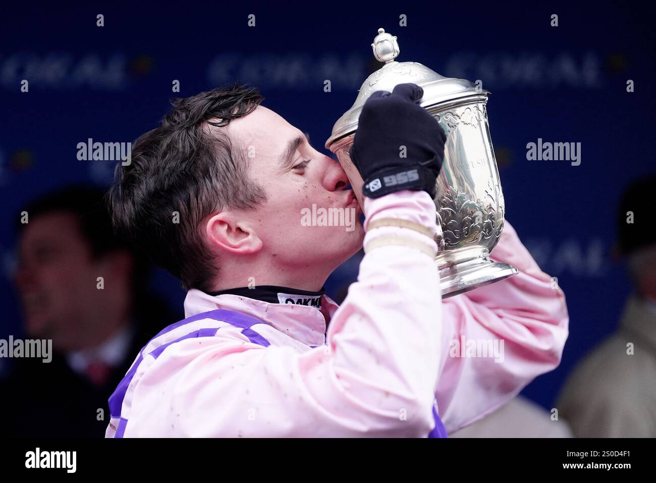 Jockey Charlie Hammond kisses the trophy after winning the Coral Welsh ...