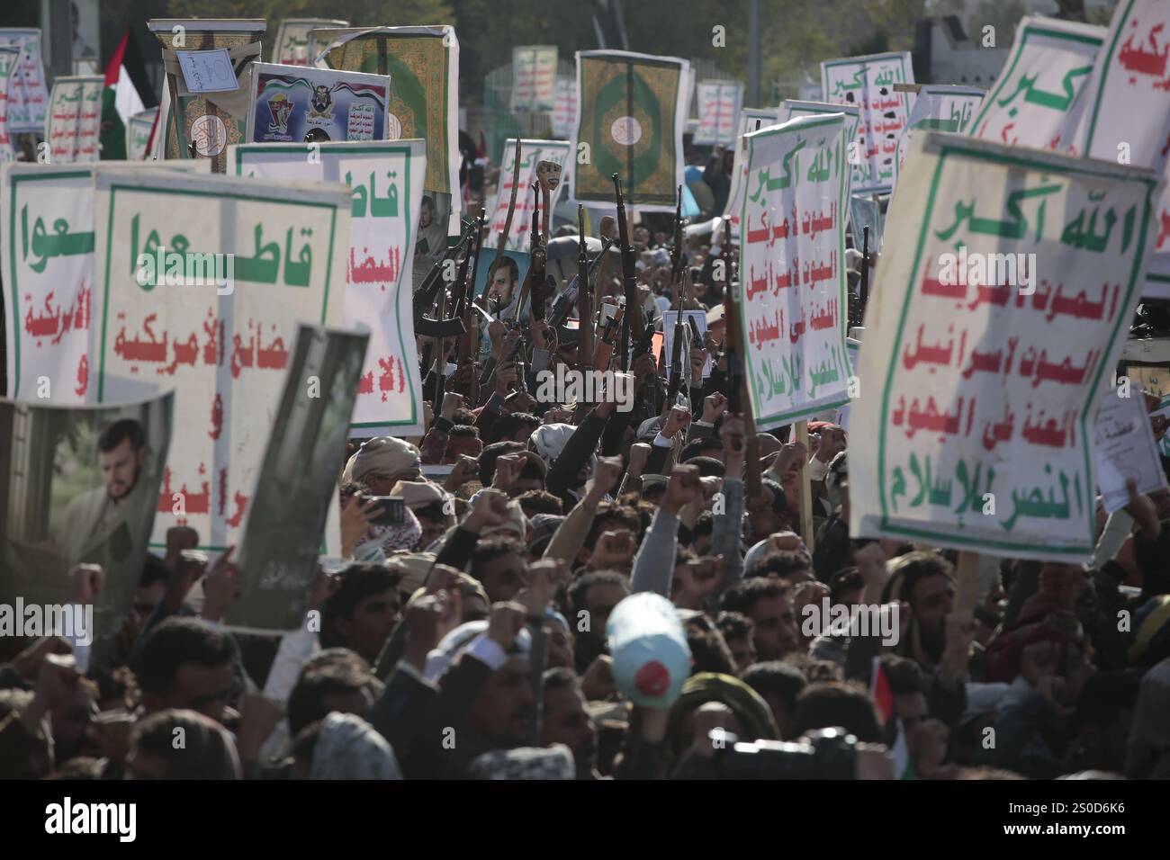 27 December 2024, Yemen, Sana'a: Yemen's Houthi supporters hold flags ...