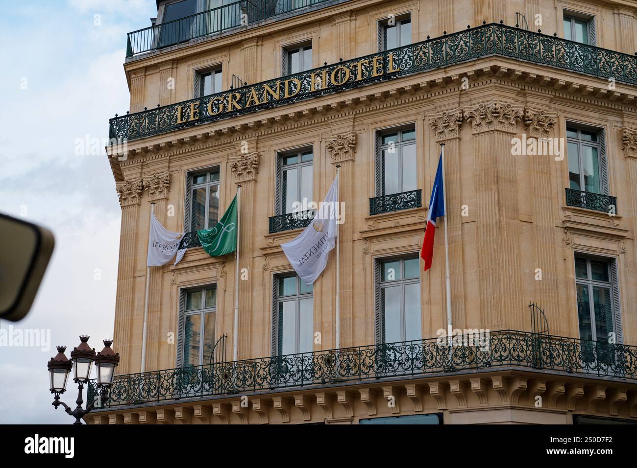 Elegant architecture of a historic hotel in Paris with flags waving ...