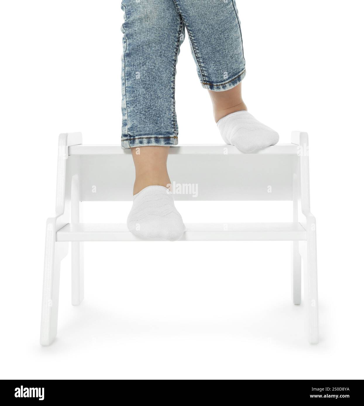 Little girl standing on step stool against white background, closeup ...