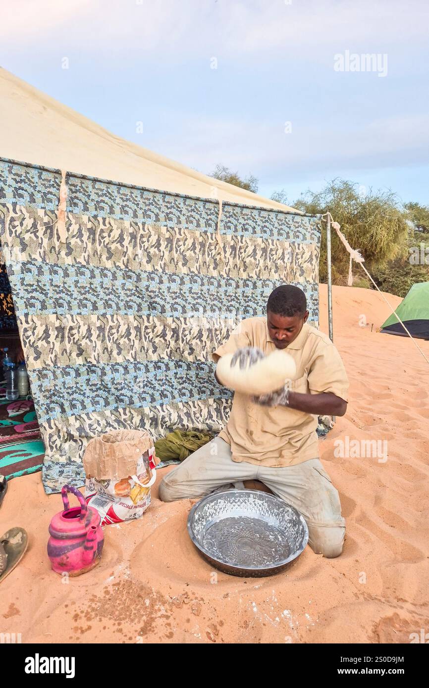 Mauritania, Azweiga, cook preparing traditional desert bread cooked ...