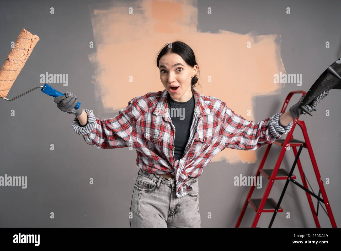 Happy female painter preparing to paint the walls. Repair of apartments ...