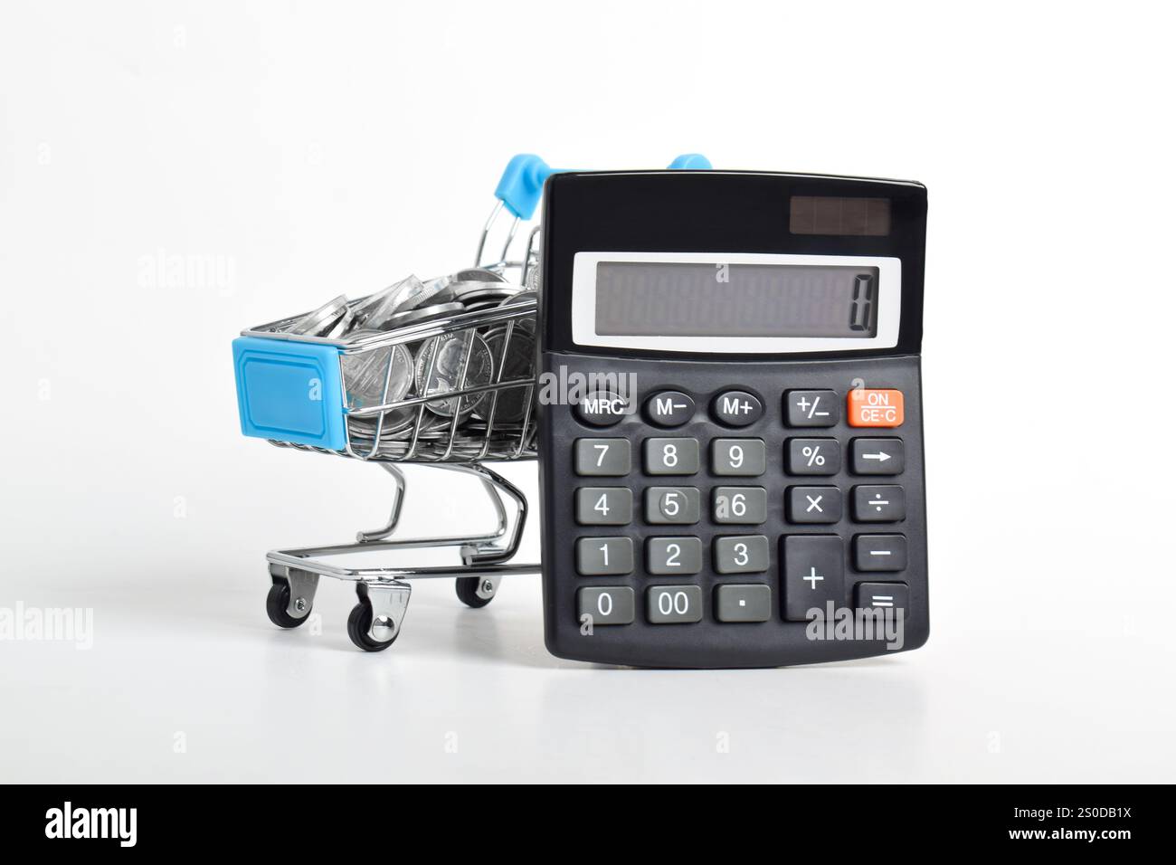 Calculator and shopping cart full of coins isolated on white background ...