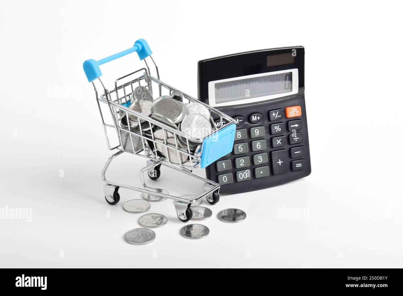 Calculator and shopping cart full of coins isolated on white background ...