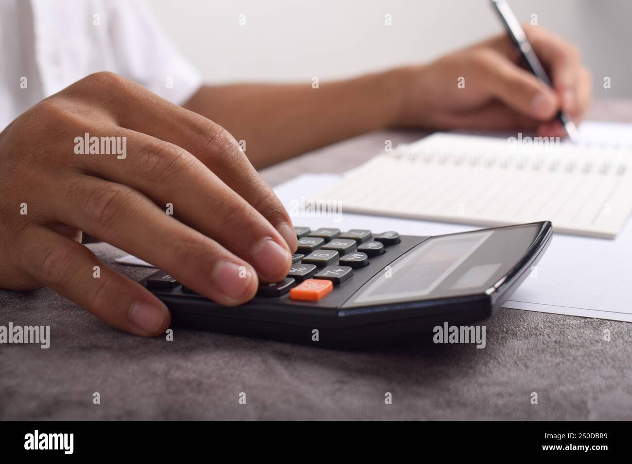 Close-up businessman's hands using calculator to calculate home finance ...