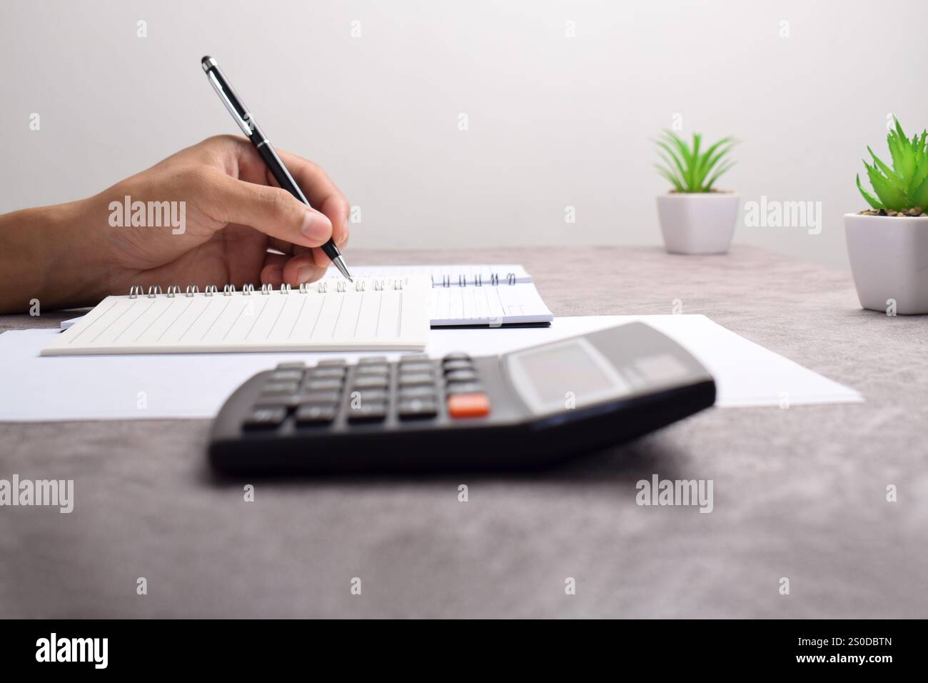Businessman using a calculator to calculate numbers on a company's ...
