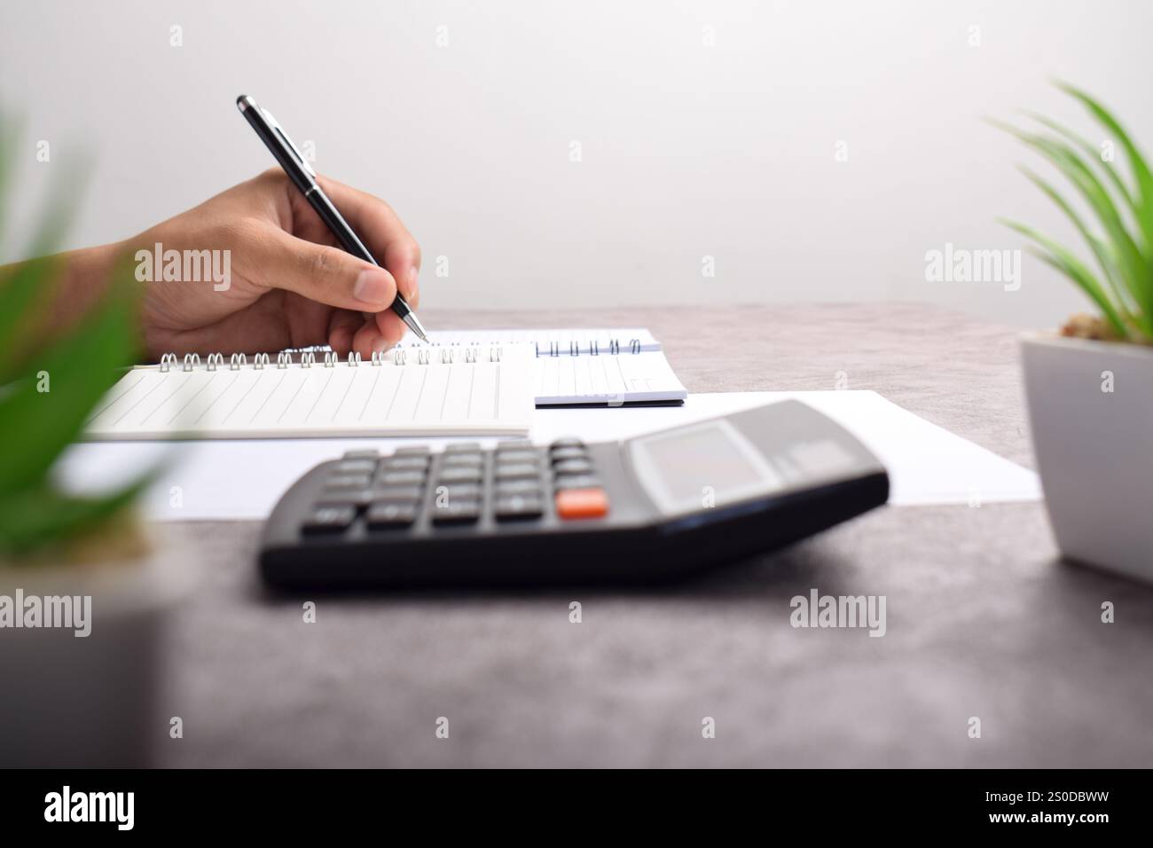 Businessman using a calculator to calculate numbers on a company's ...
