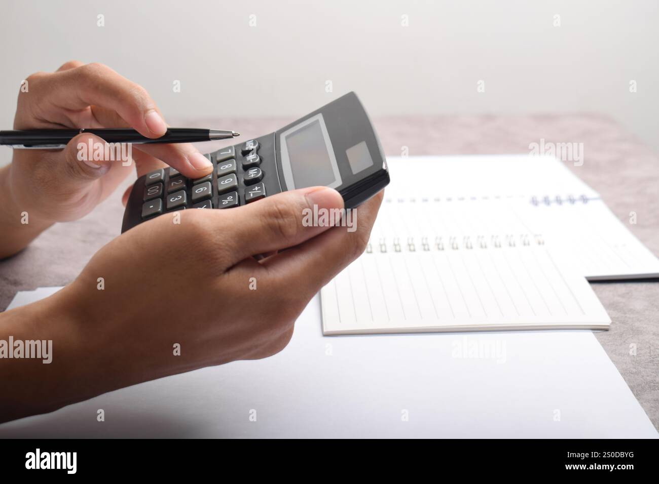 Man using calculator to count income and outcome Stock Photo - Alamy