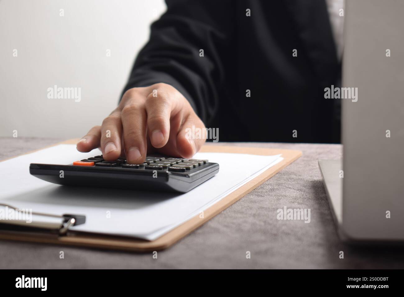 Accountant working on desk using calculator to calculate financial ...