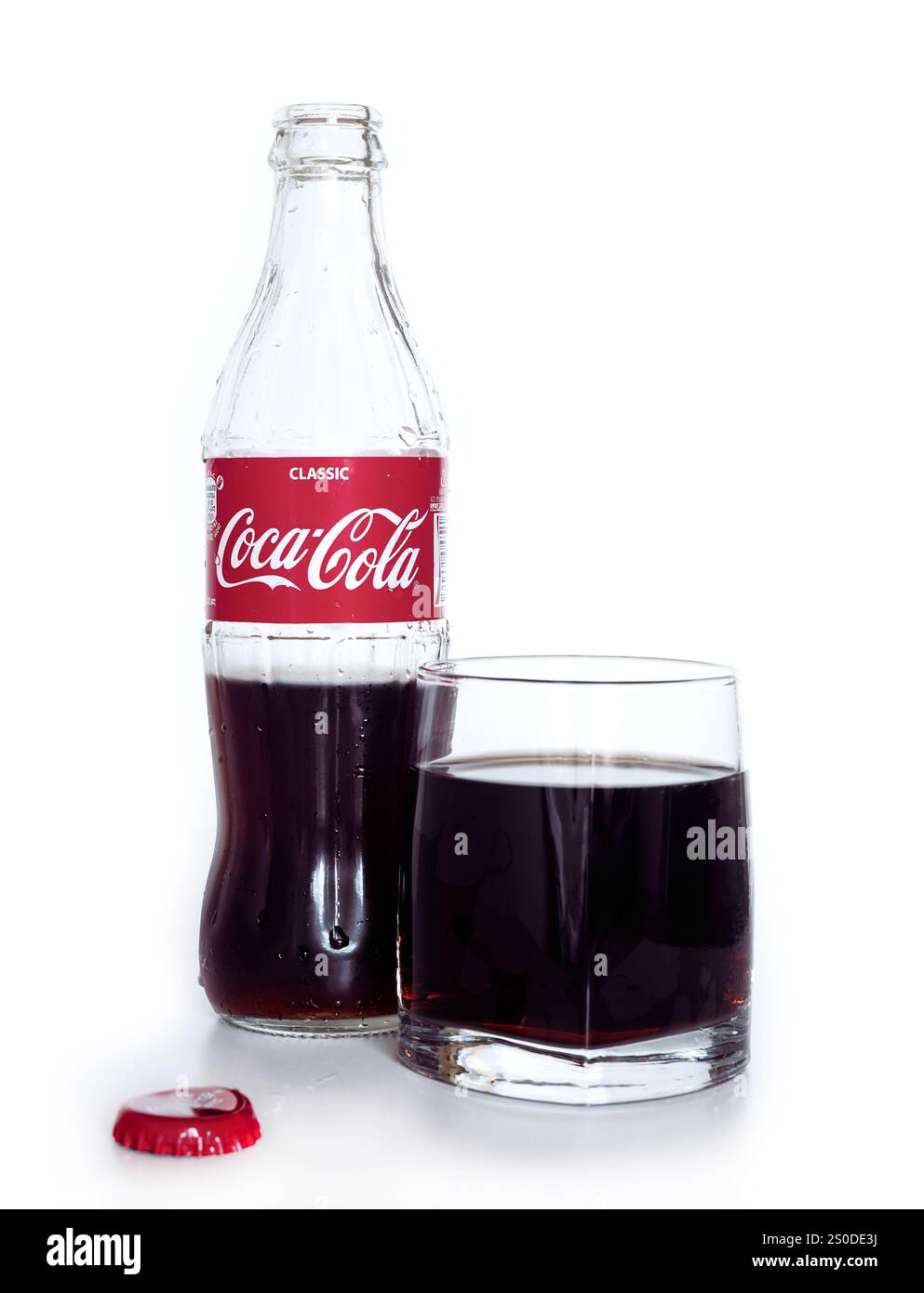 Coca-Cola Classic opened bottle with filled glass standing on white ...
