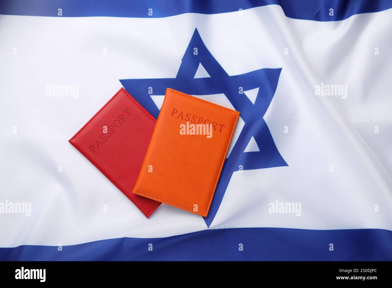 Passports in color covers on flag of Israel, top view Stock Photo - Alamy