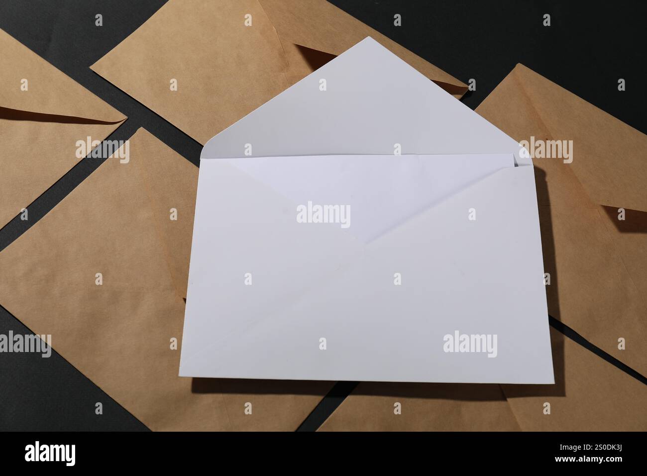 Paper envelopes with letter on black background, above view. Mockup for ...