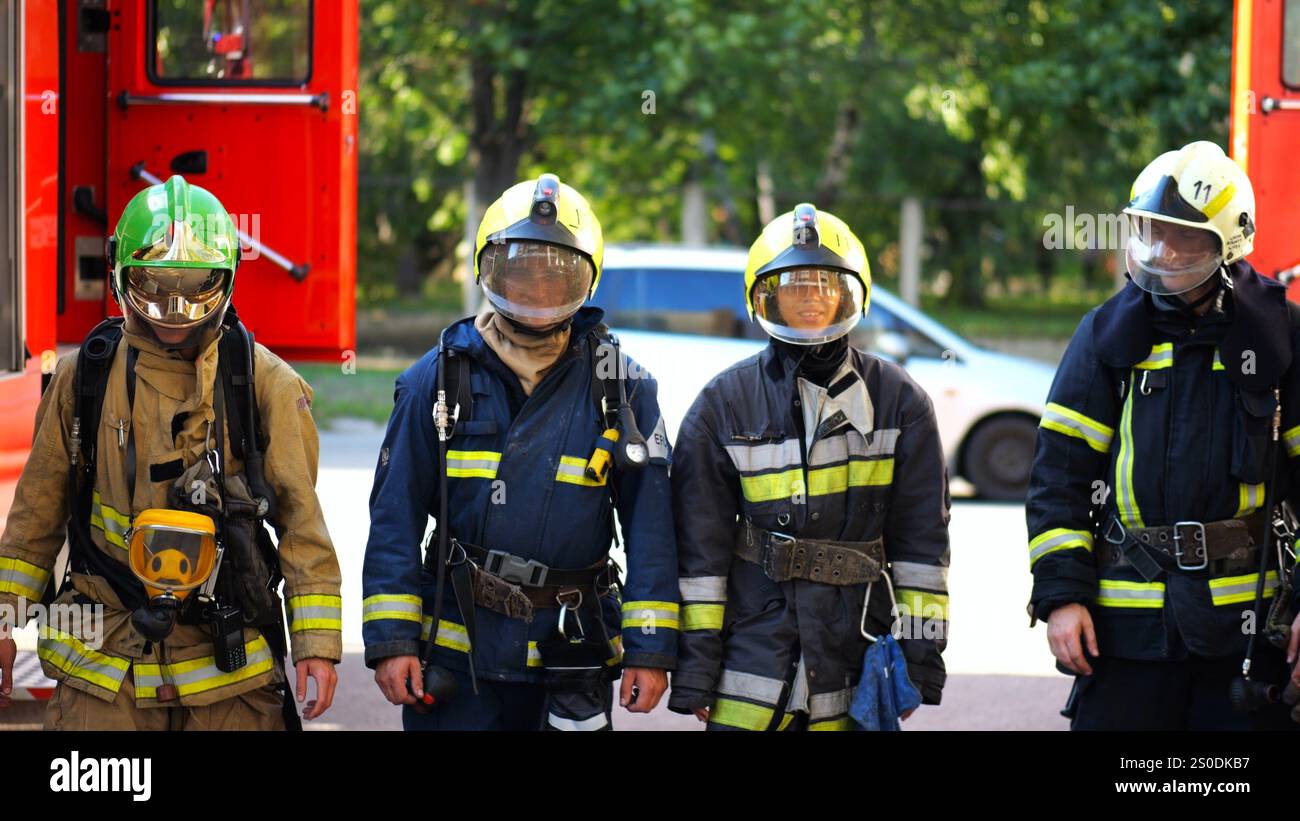 Portrait of male and female firefighters in helmets and protective ...