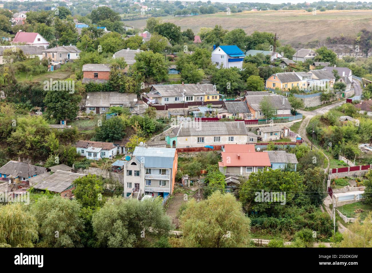 A small town with houses and trees. The houses are mostly white and ...