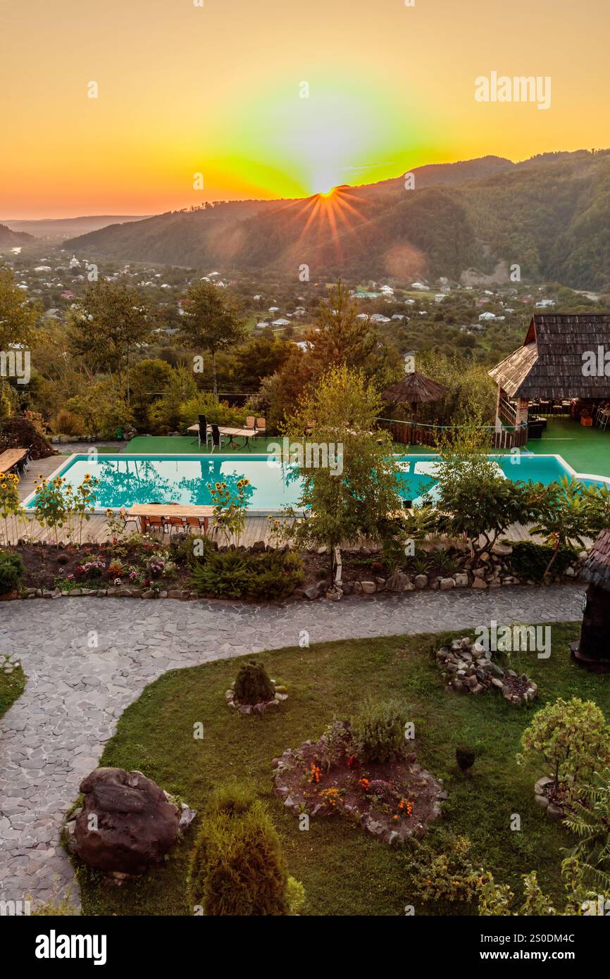 A beautiful view of a pool and a mountain with a sunset in the ...